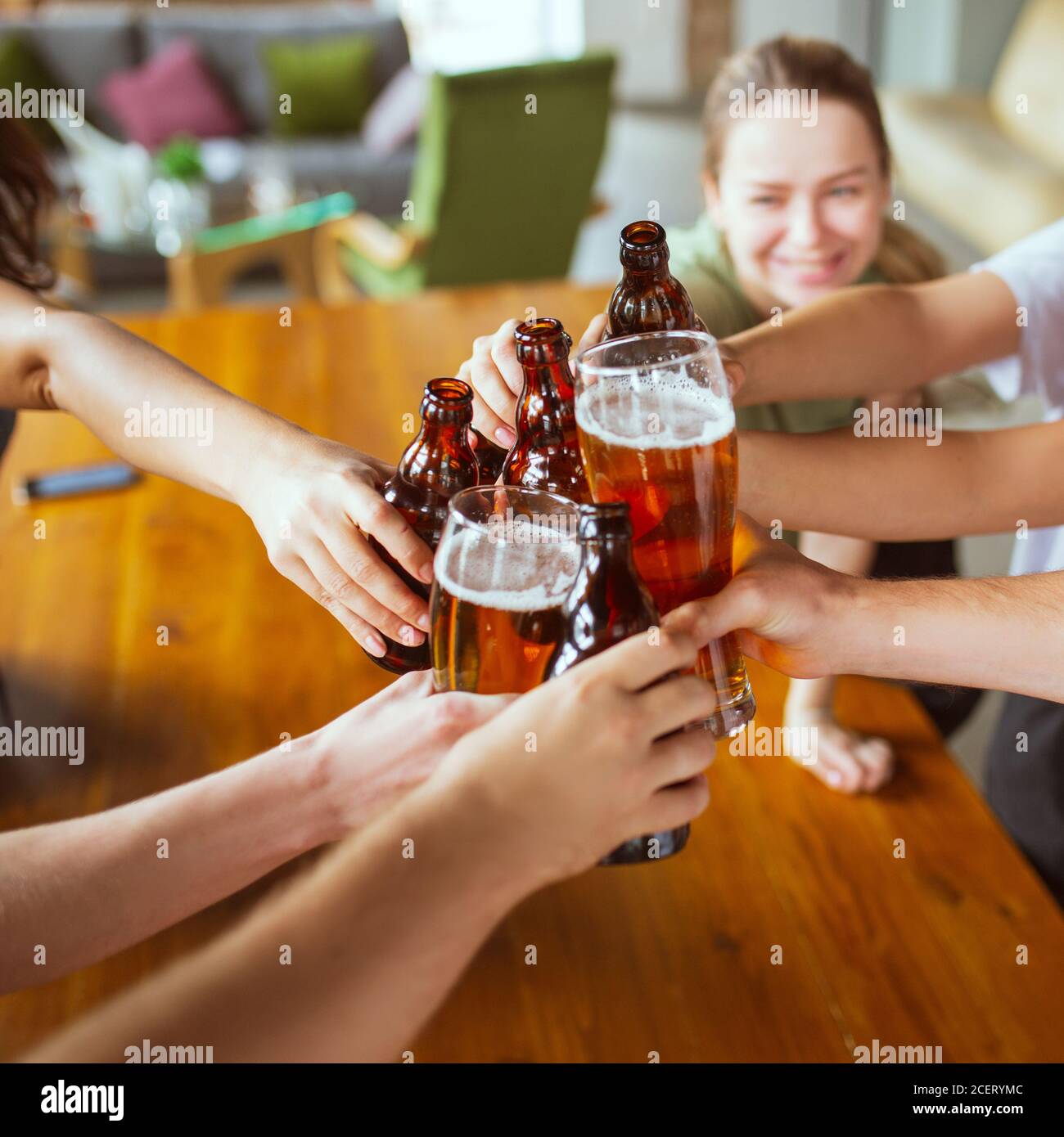 Close up clinking. Young group of friends drinking beer, having fun ...