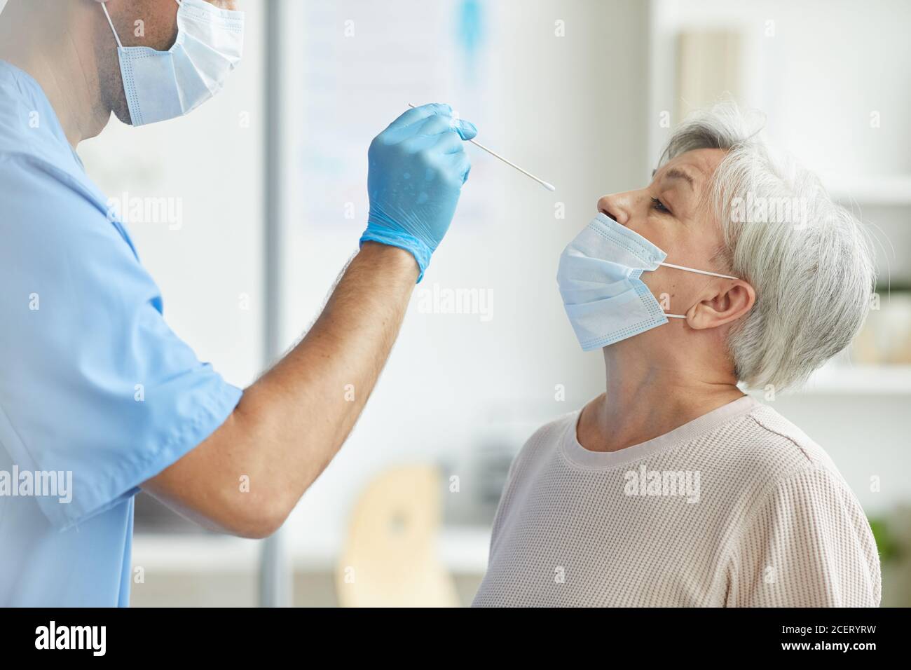 Side view shot of professional medical worker taking nasal swab sample ...