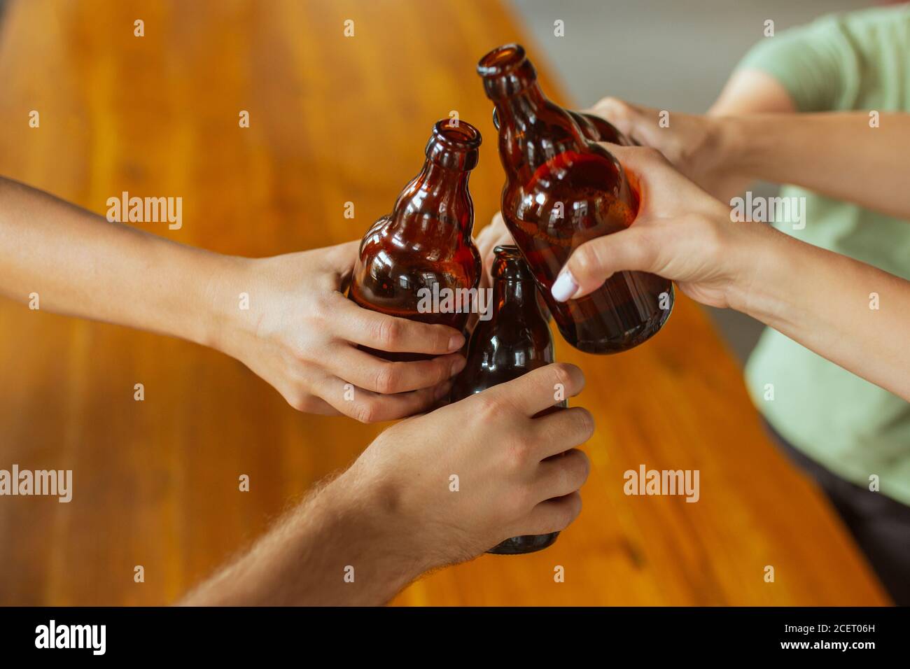 Close up clinking. Young group of friends drinking beer, having fun ...