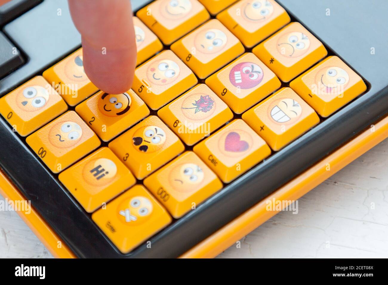 A finger presses a button on the keyboard with a smiley face. Close up ...