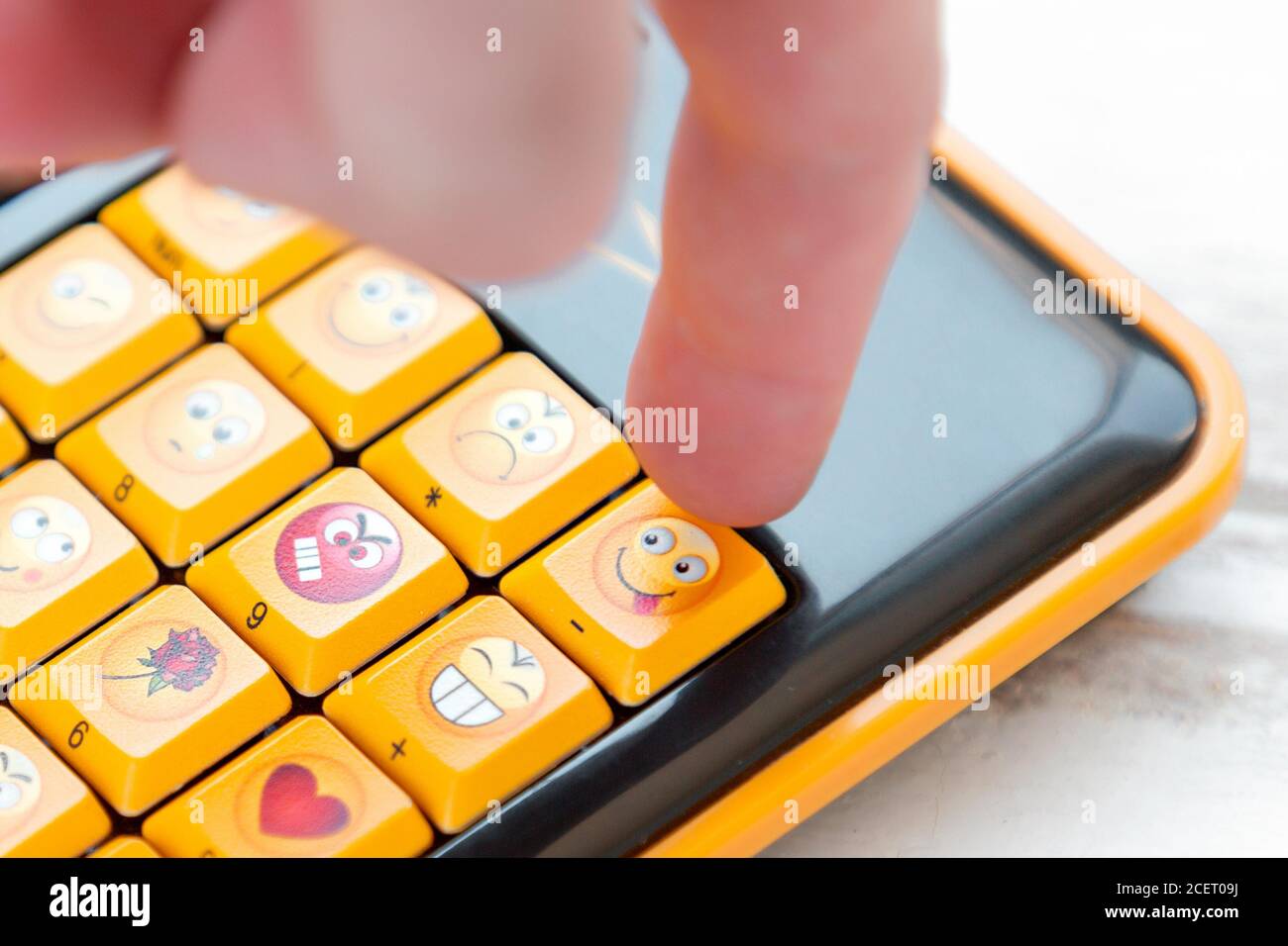 A males finger presses a button with a happy smiley face on the ...