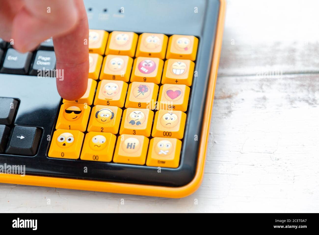 A male hand presses a button with a cool smiley face in glasses on the ...