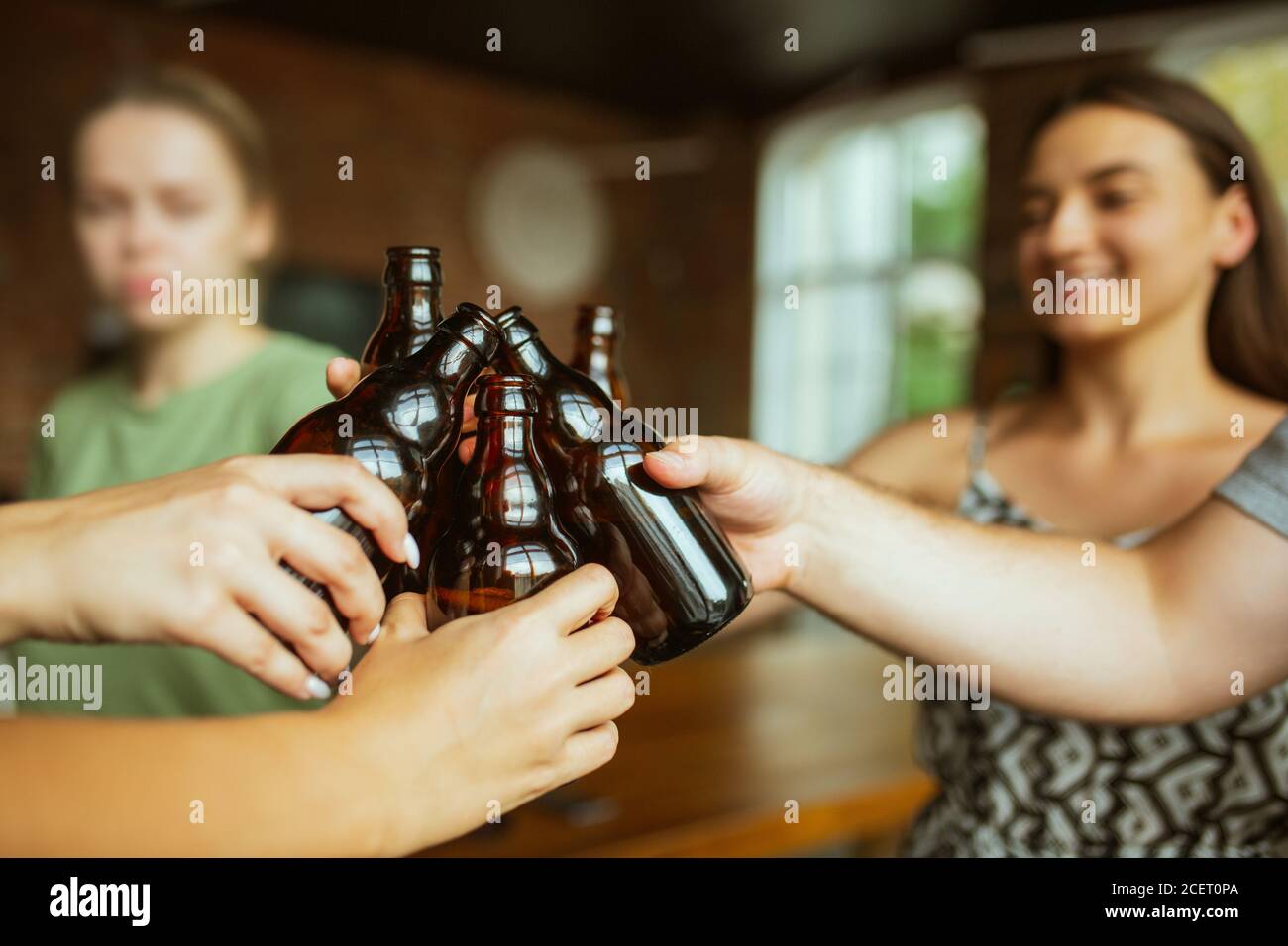 Close up clinking. Young group of friends drinking beer, having fun ...