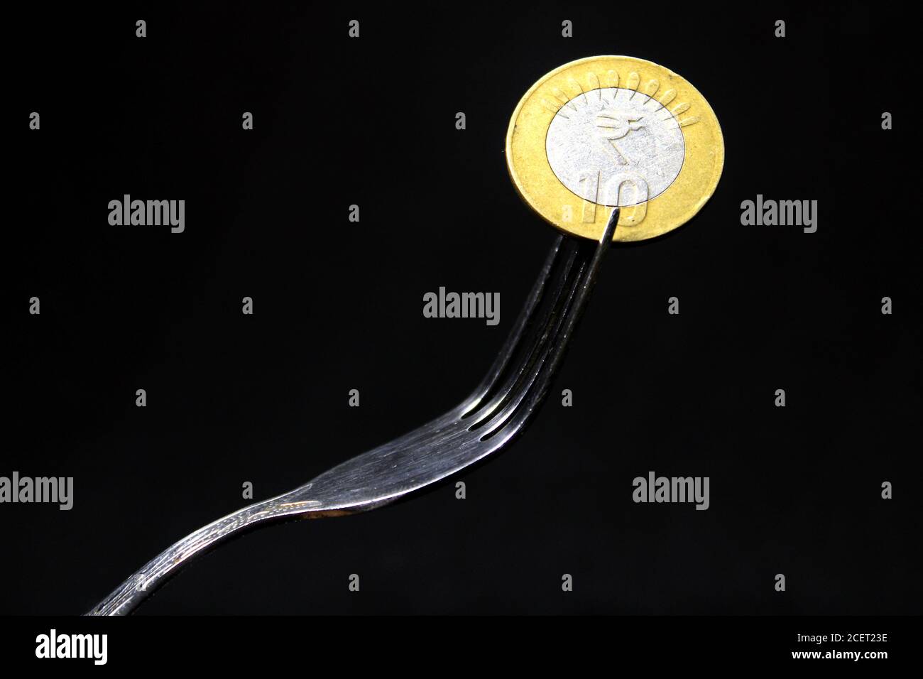 Indian ten rupee coin with Stainless Steel Table Fork isolated on black ... Indian ten rupee coin with Stainless Steel Table Fork isolated on black ...