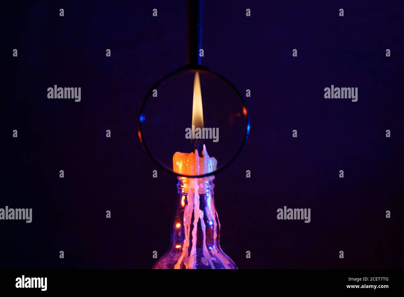 Fire of a candle in a bottle through a magnifying glass Stock Photo - Alamy