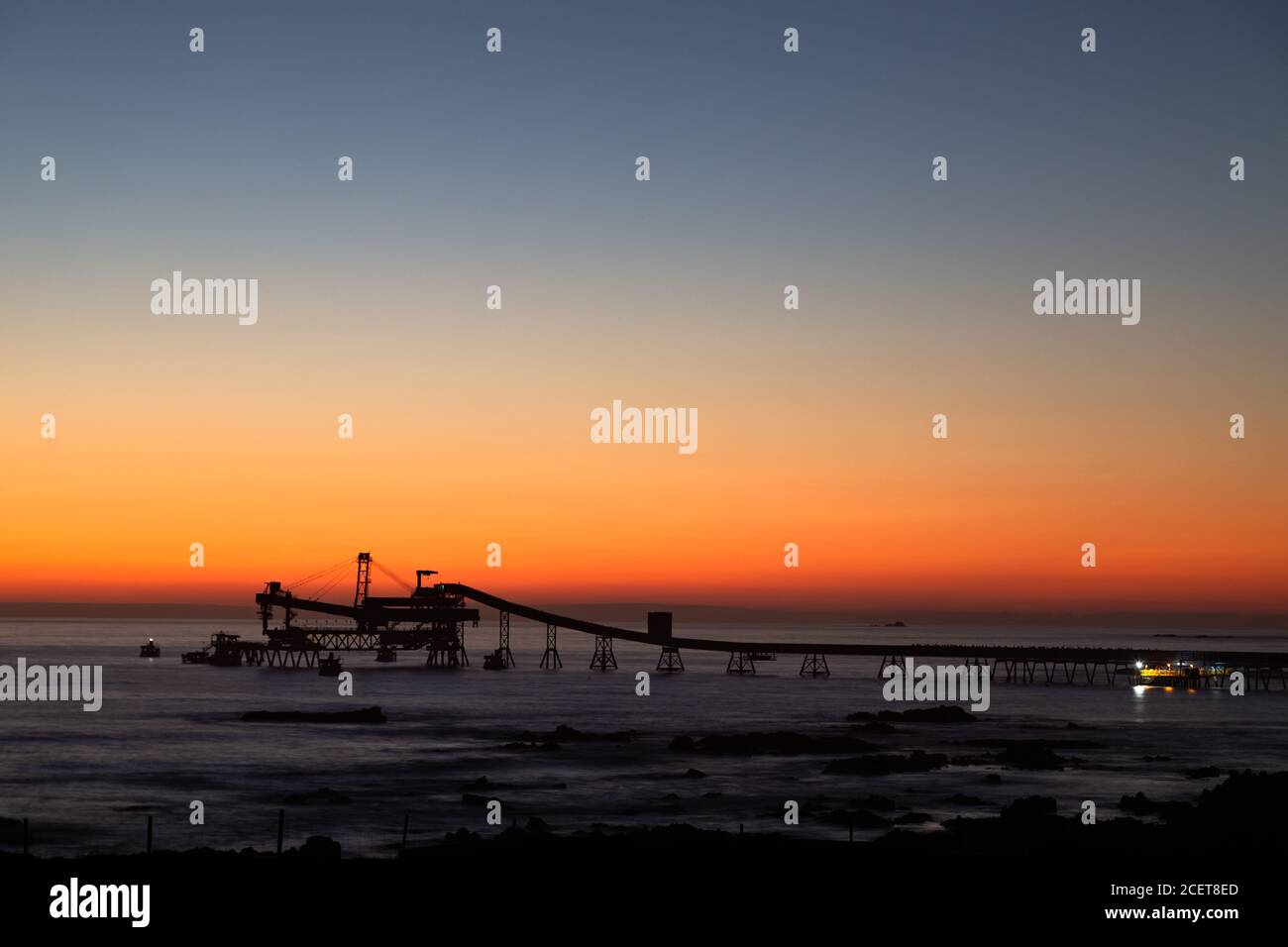 Ocean gleaming under the orange and blue sky Stock Photo - Alamy