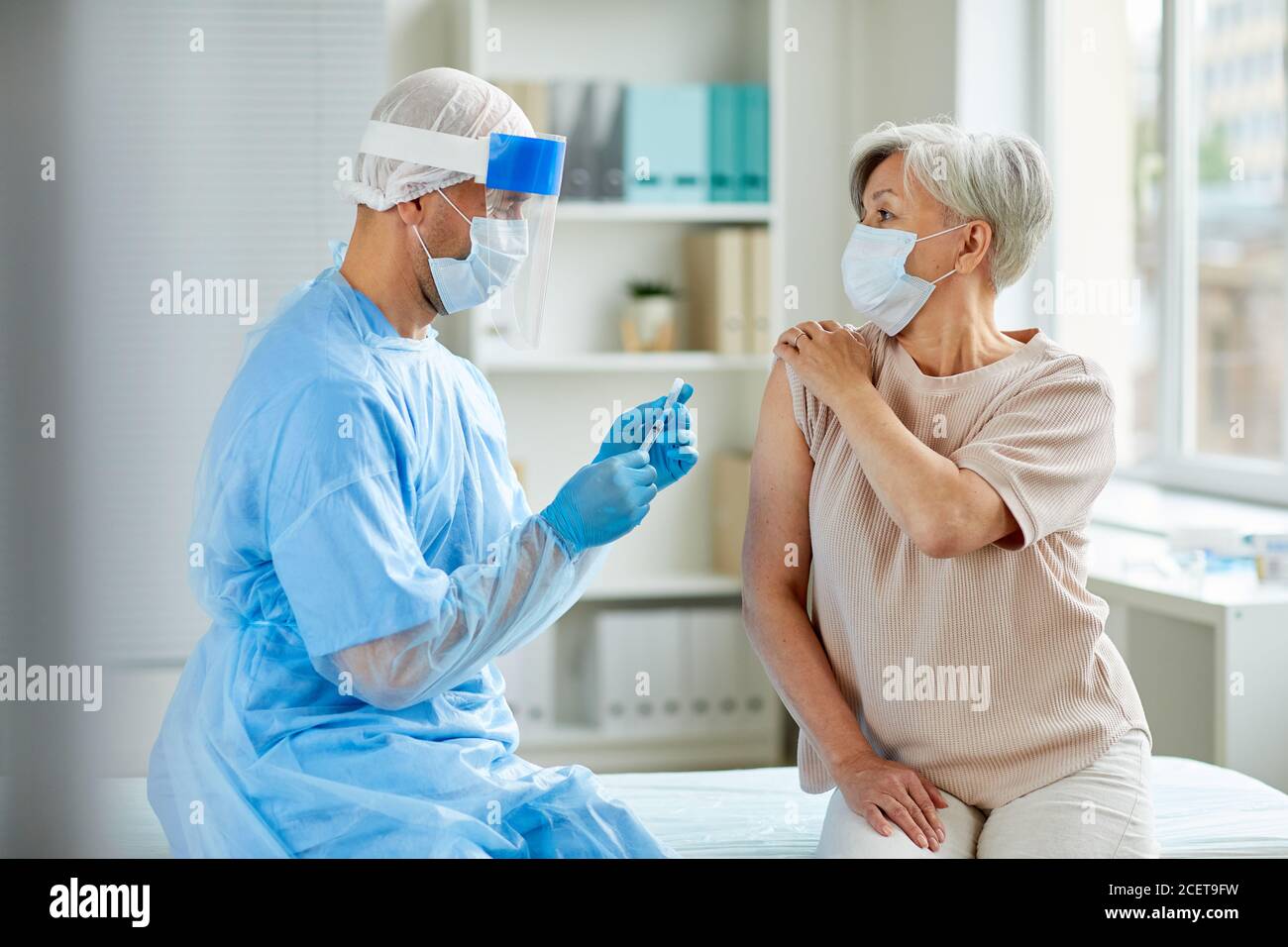 Nurse giving male patient injection hi-res stock photography and images ...