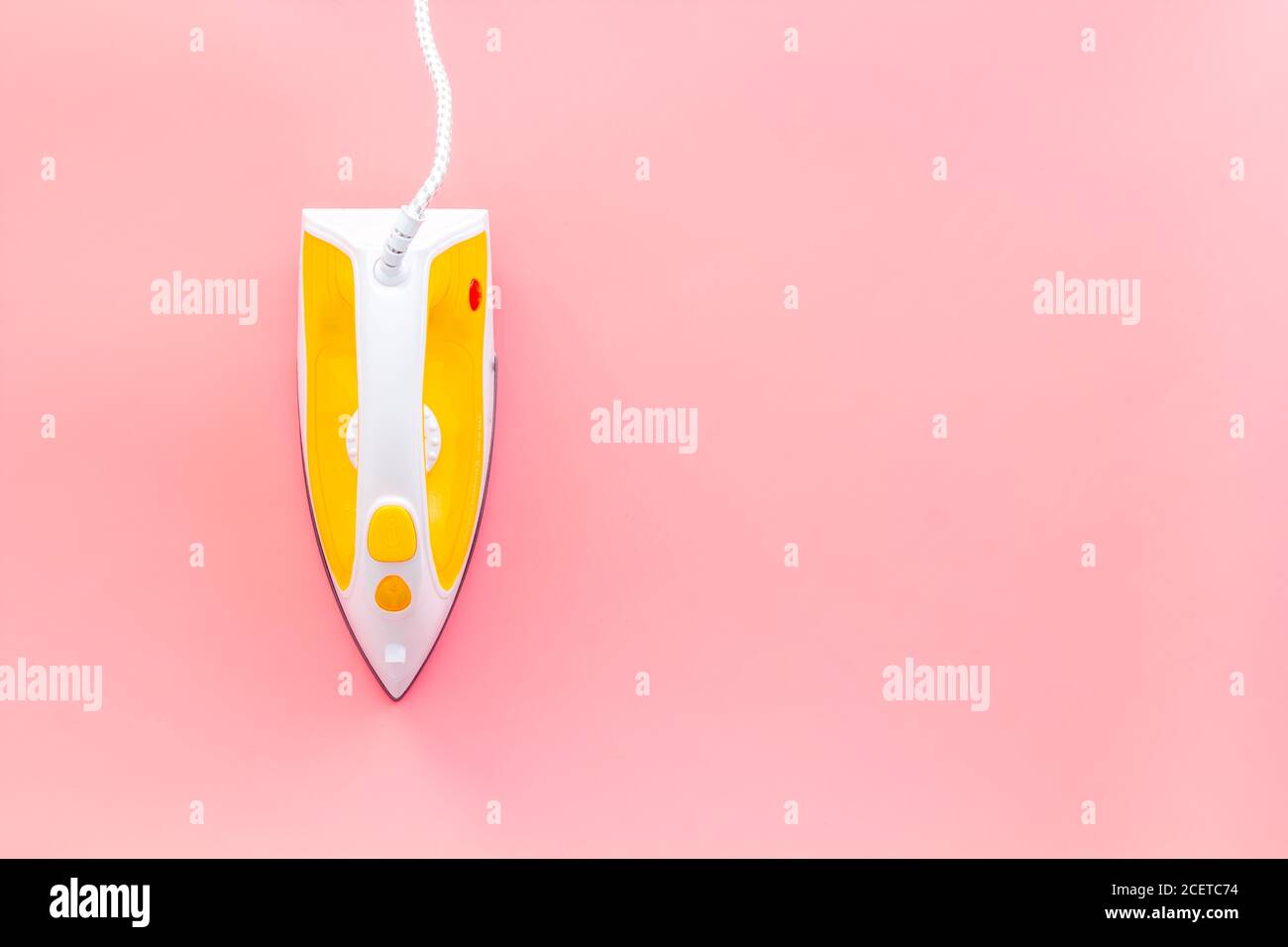 Yellow iron on ironing board. Top view, copy space Stock Photo - Alamy