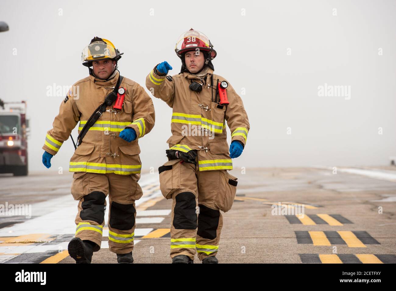 Two firefighters walking towards the camera during an emergency ...
