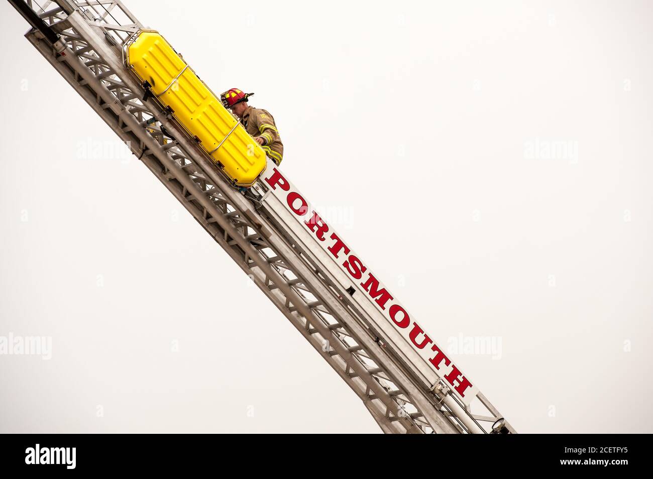 A fireman climbing the ladder on a fire truck during a full-scale ...