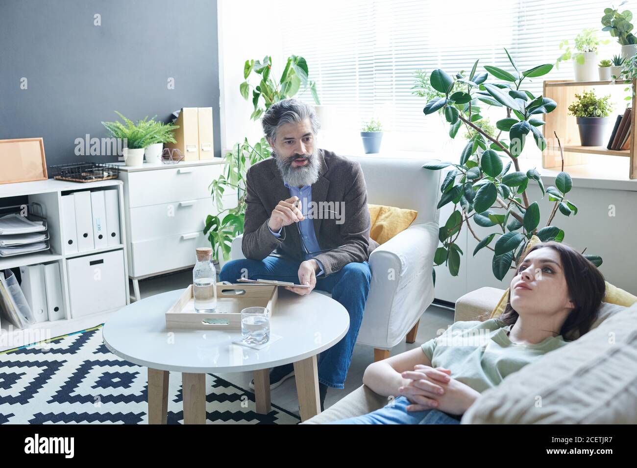 Professional psychologist working with sad young woman on therapy ...
