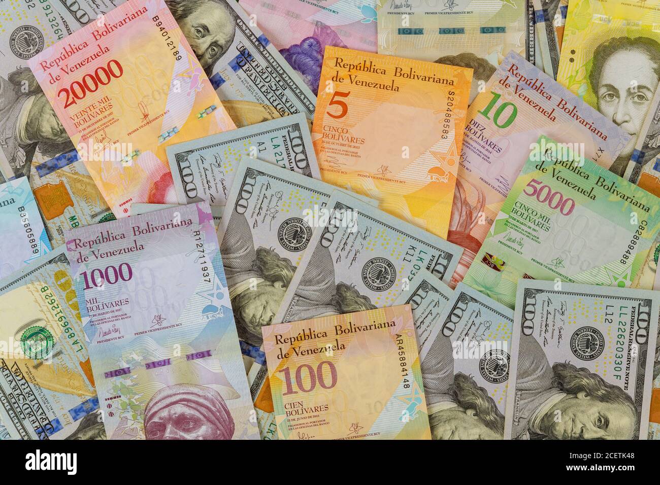 American dollar bills notes over Venezuelan Bolivar banknote with ...
