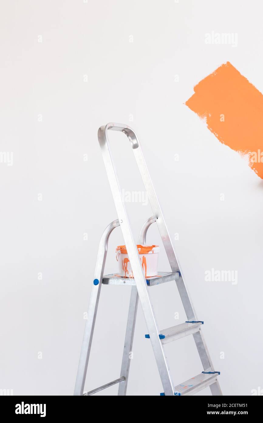 Ladder with paint in bucket near color wall indoors. Renovation and ...