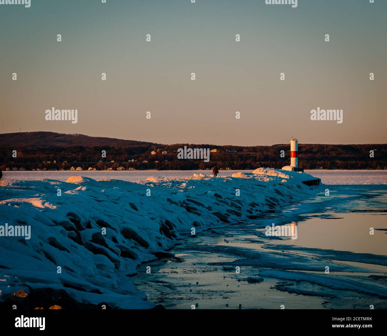 Lone tourist visiting a frozen lighthouse in Petoskey Michigan Stock ...