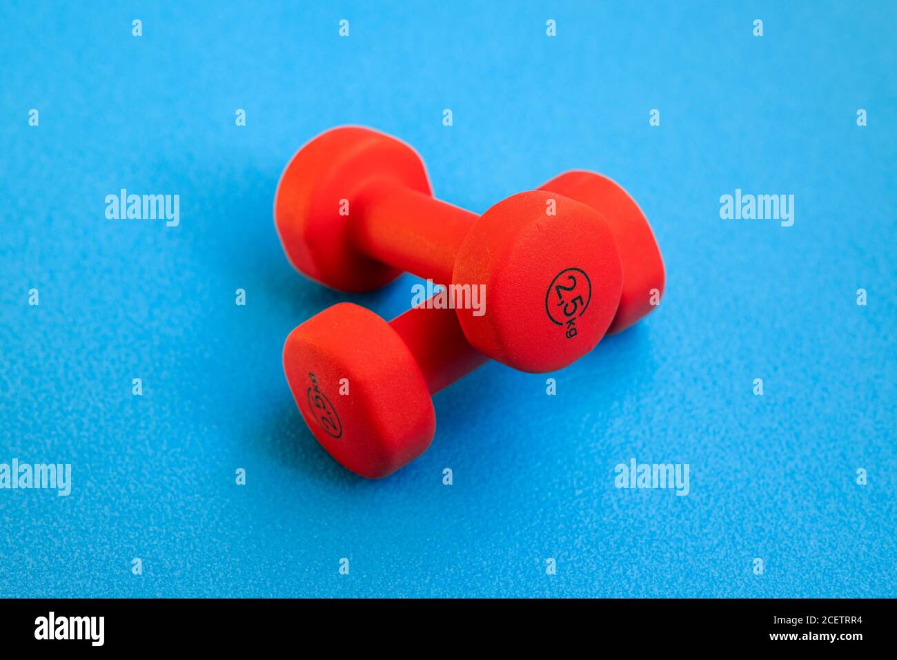 Two red weights 2,5 kg on the blue background Stock Photo - Alamy