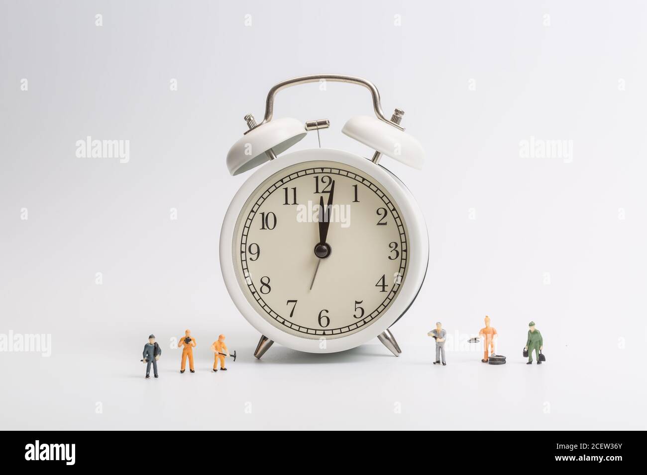 Alarm clock worker on white background Stock Photo - Alamy