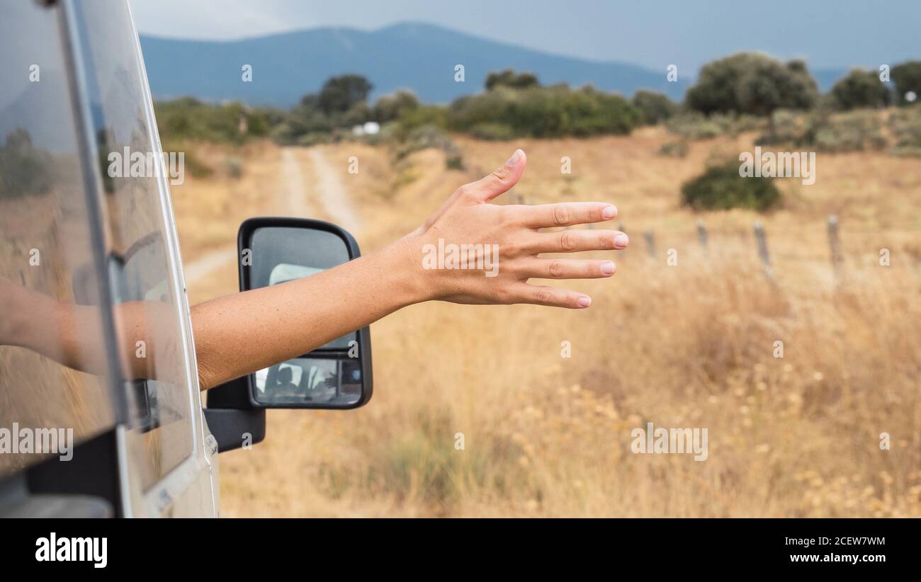 Female holding her hand out of the window of a car Stock Photo - Alamy