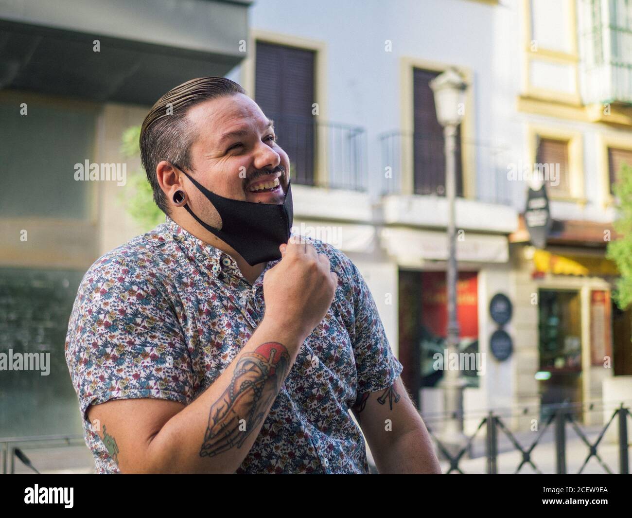 Male pulling down his mask and laughing outdoors Stock Photo - Alamy