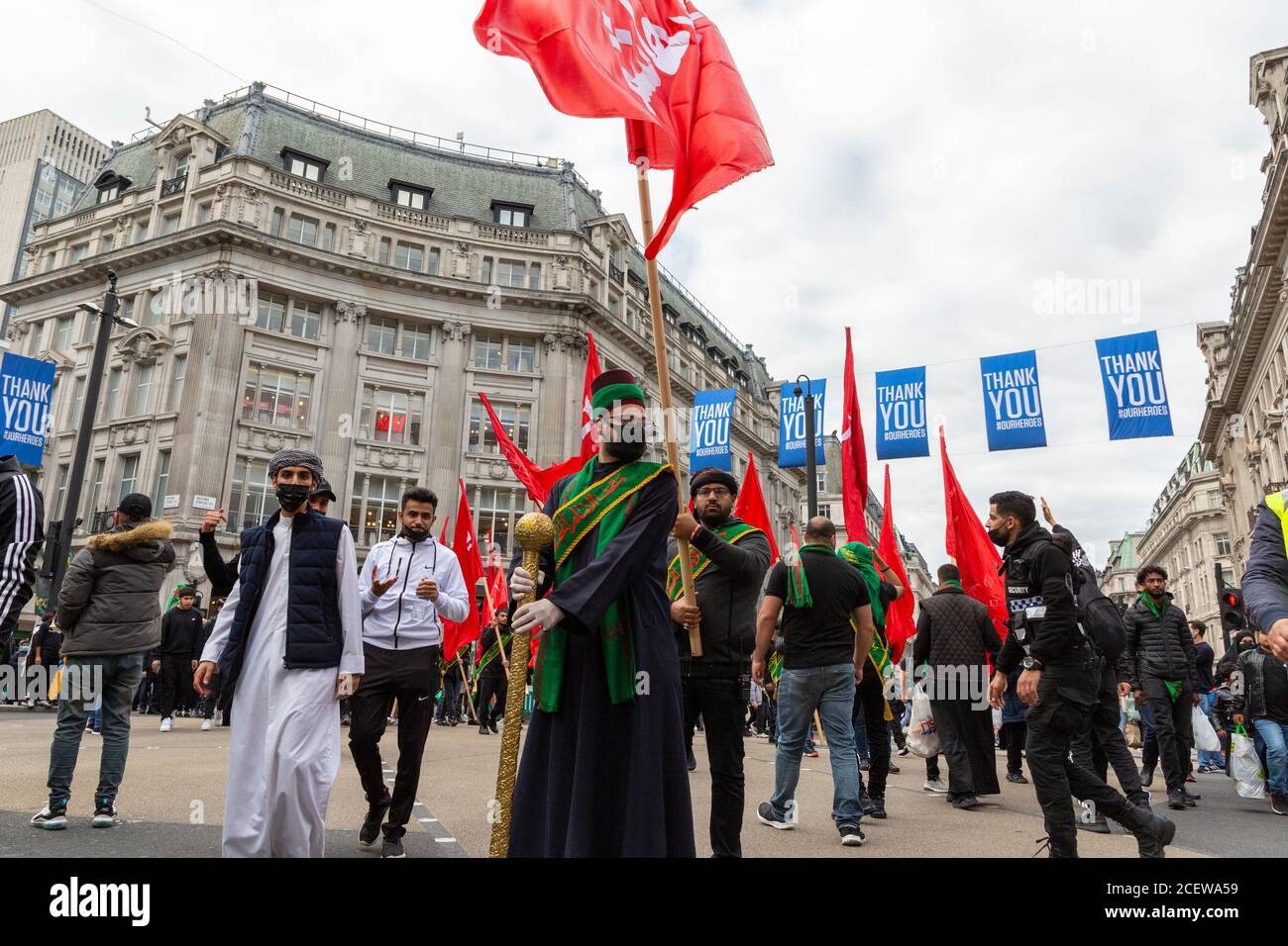 Crowd marching with red flag during Ashura Day event for Shia Muslims ...