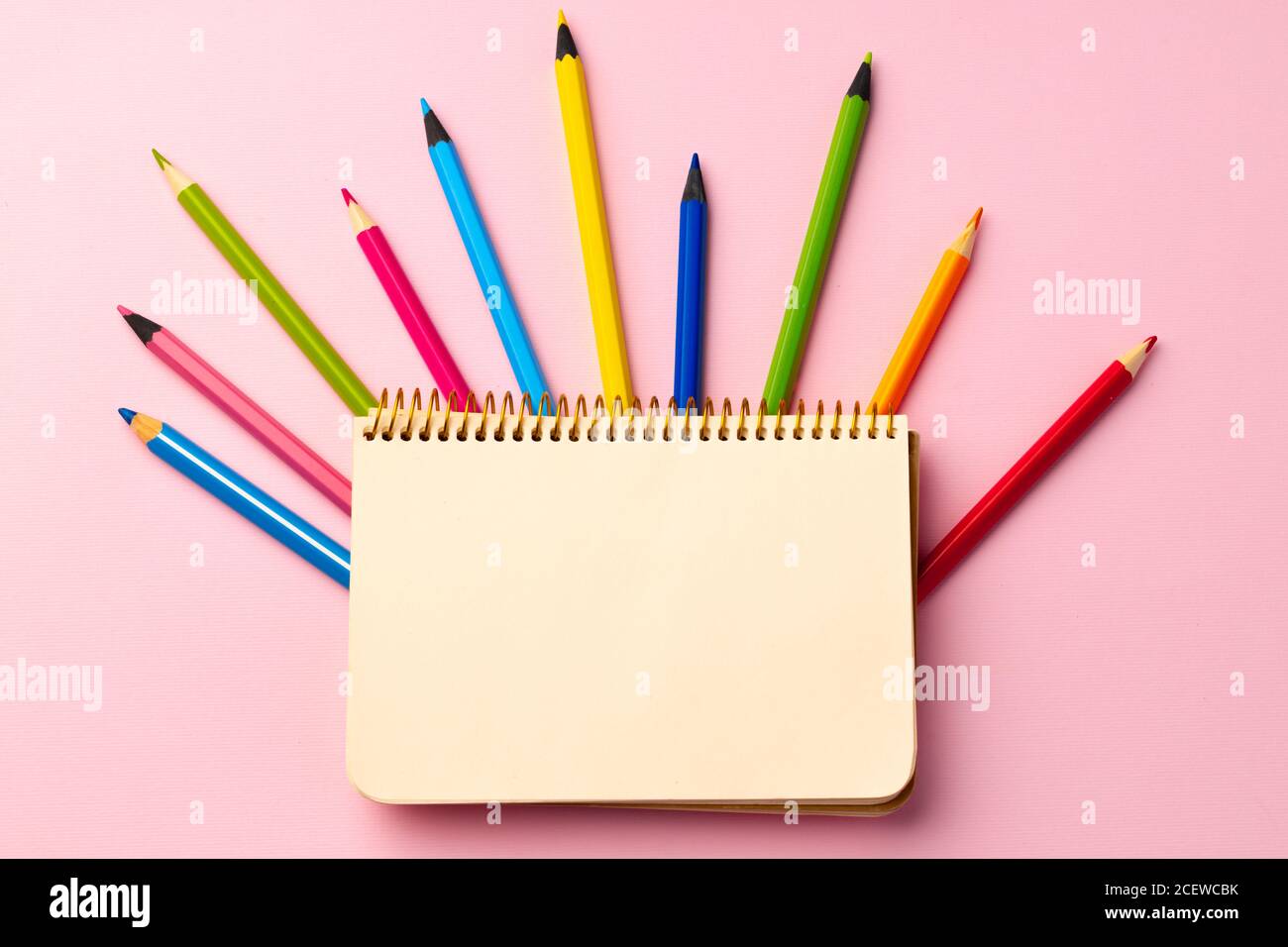 Open notepad and color pencils on paper background Stock Photo - Alamy