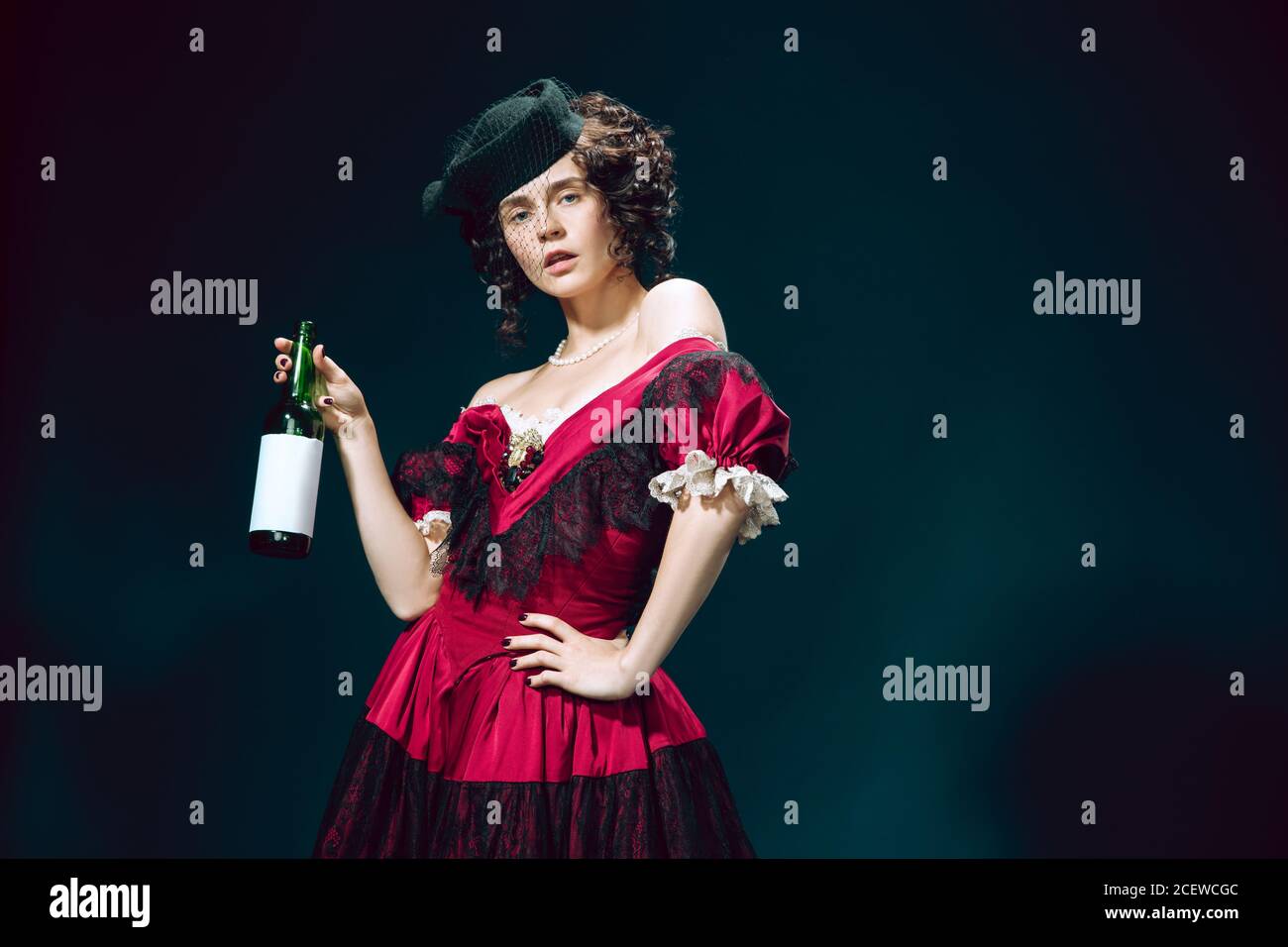 Wine drinking. Young woman as Anna Karenina isolated on dark blue ...