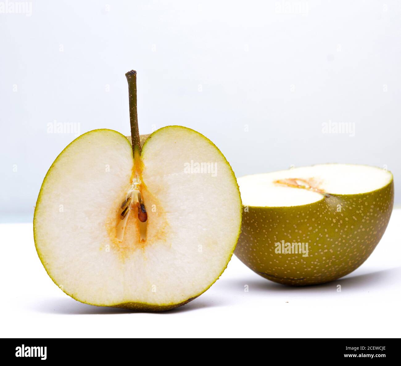 halved ripe pear on white background image Stock Photo - Alamy