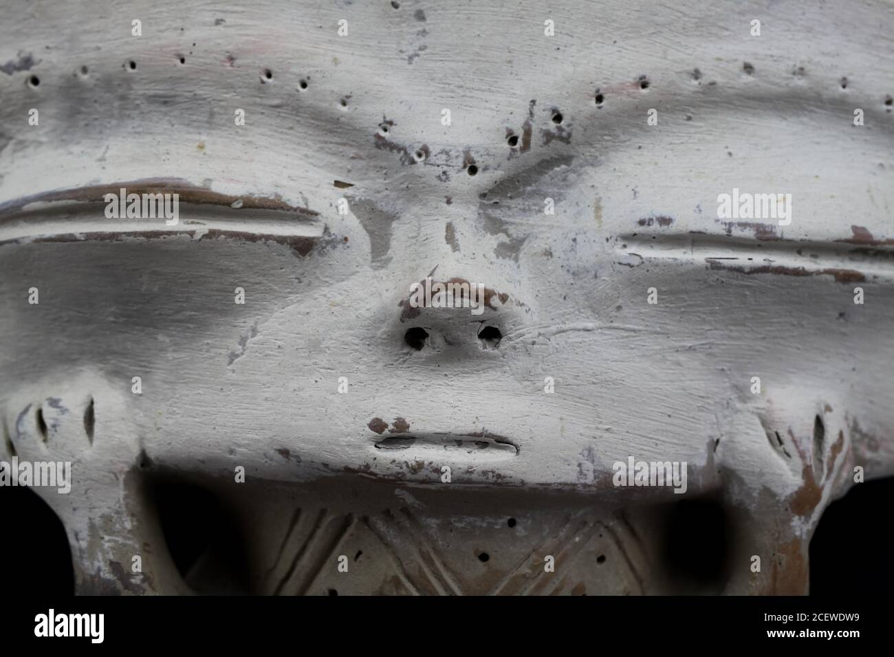 Closeup of isolated abstract inca clay figure with rectangular head and ...