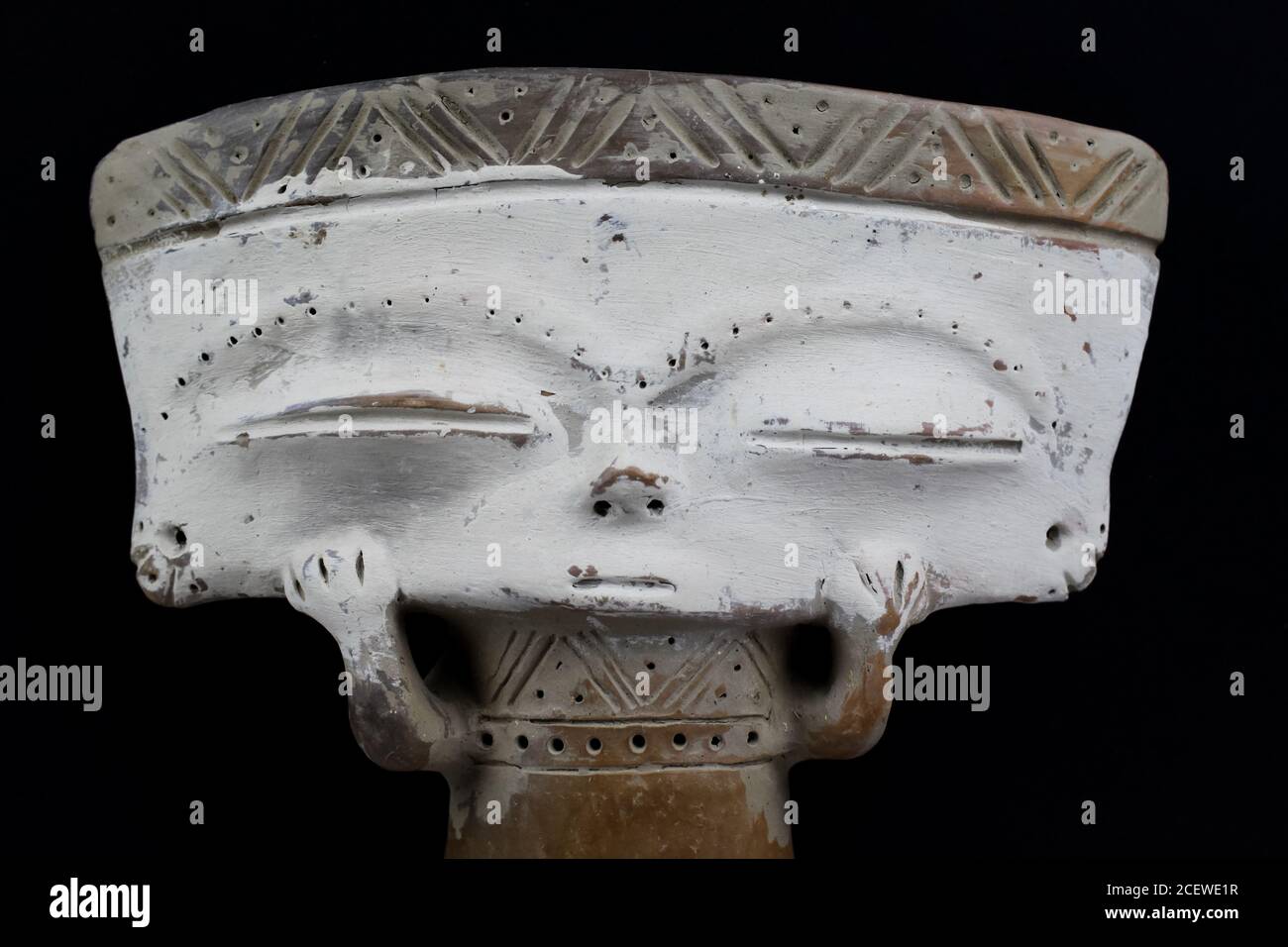 Closeup of isolated abstract inca clay figure with rectangular head and ...