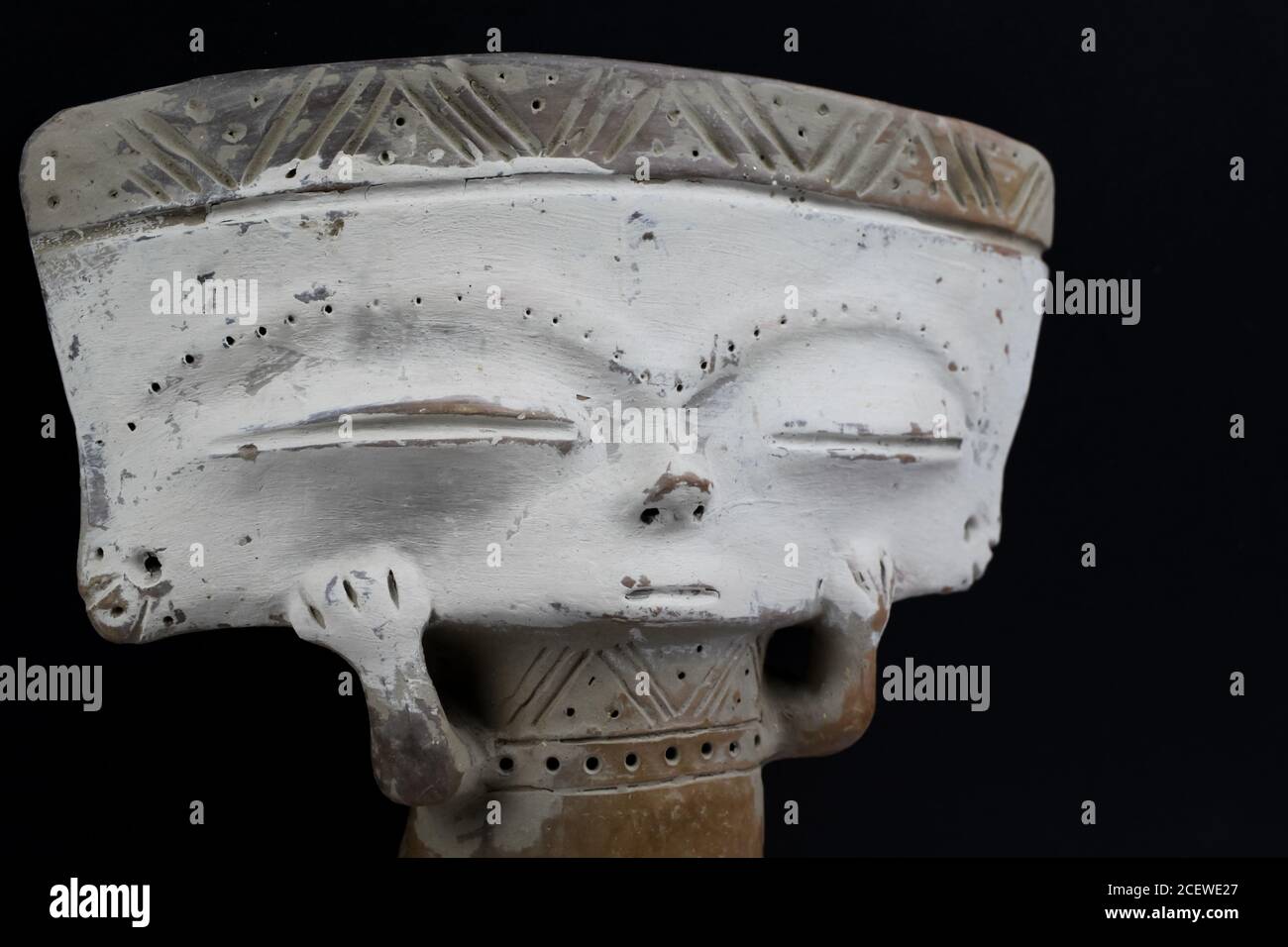 Closeup of isolated abstract inca clay figure with rectangular head and ...