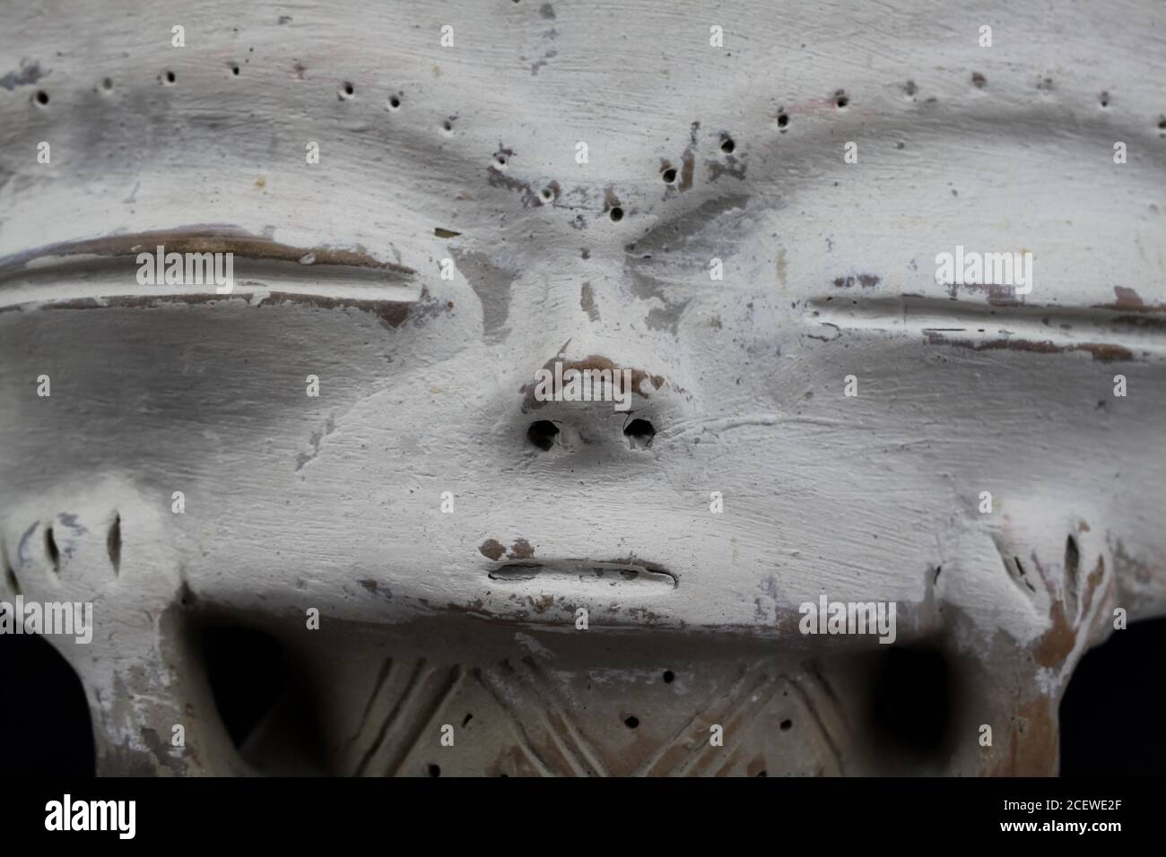 Closeup of isolated abstract inca clay figure with rectangular head and ...