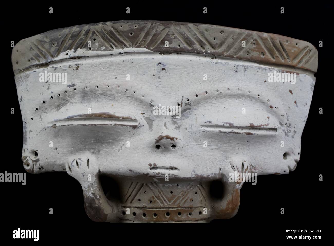 Closeup of isolated abstract inca clay figure with rectangular head and ...