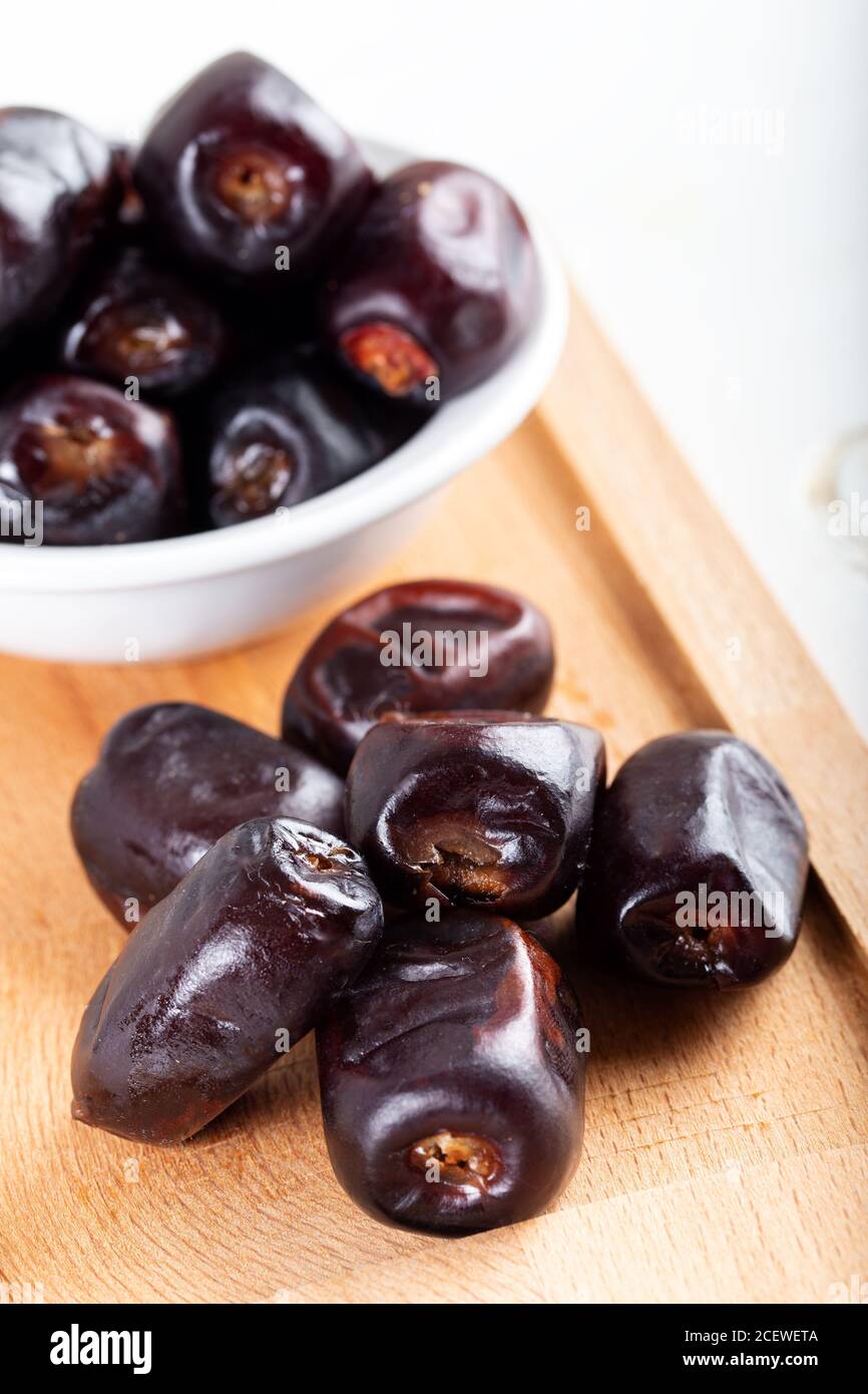Dried dates fruit in ceramic bowl on wooden table Stock Photo - Alamy