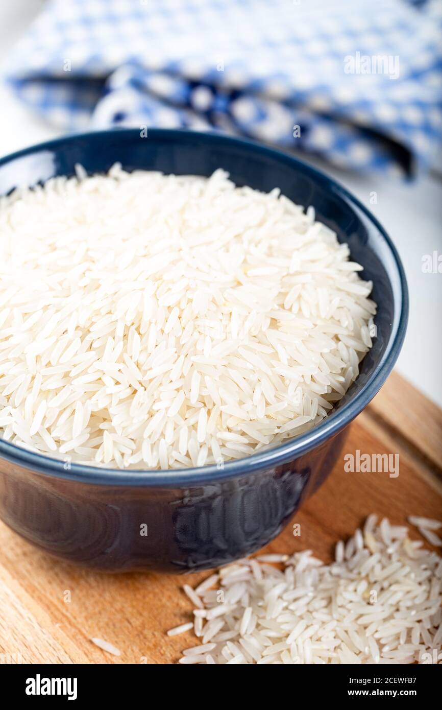 Wooden bowl full of basmati rice on wooden background Stock Photo - Alamy