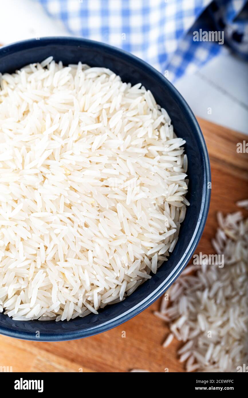 Wooden bowl full of basmati rice on wooden background Stock Photo - Alamy