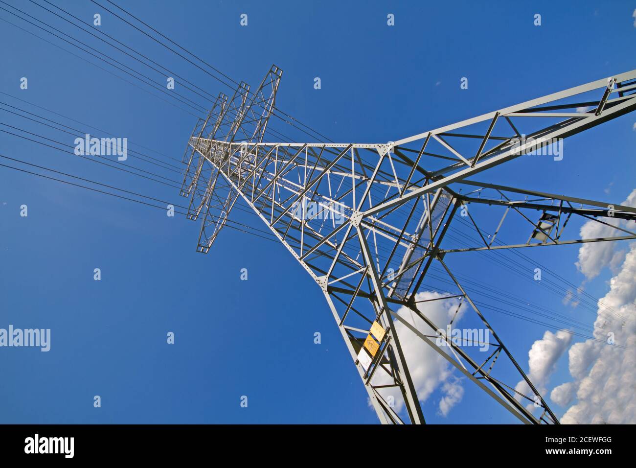 Electricity pylon with wires against blue sky Stock Photo - Alamy