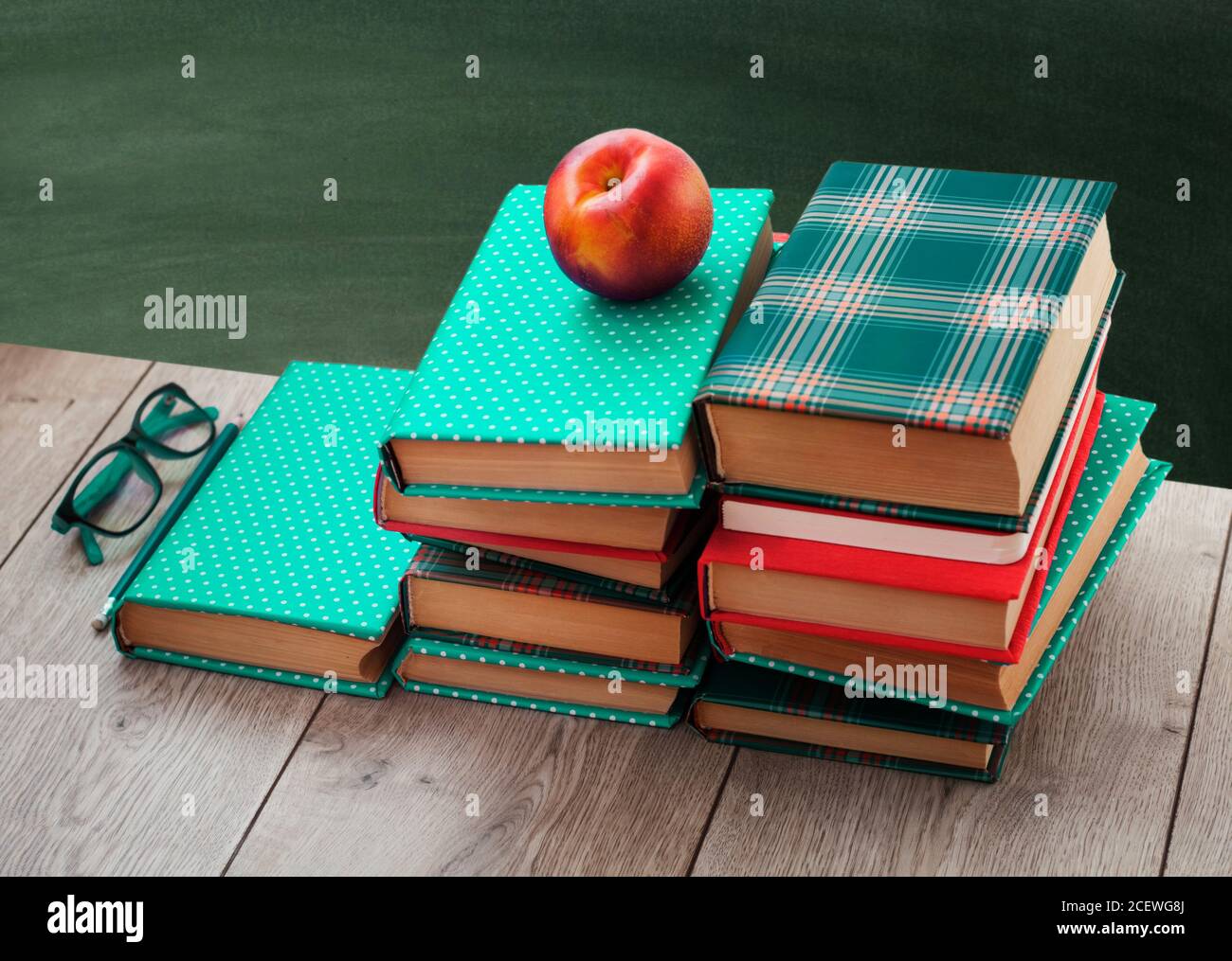 Back to school, pile of books in colorful covers and peach on wooden ...
