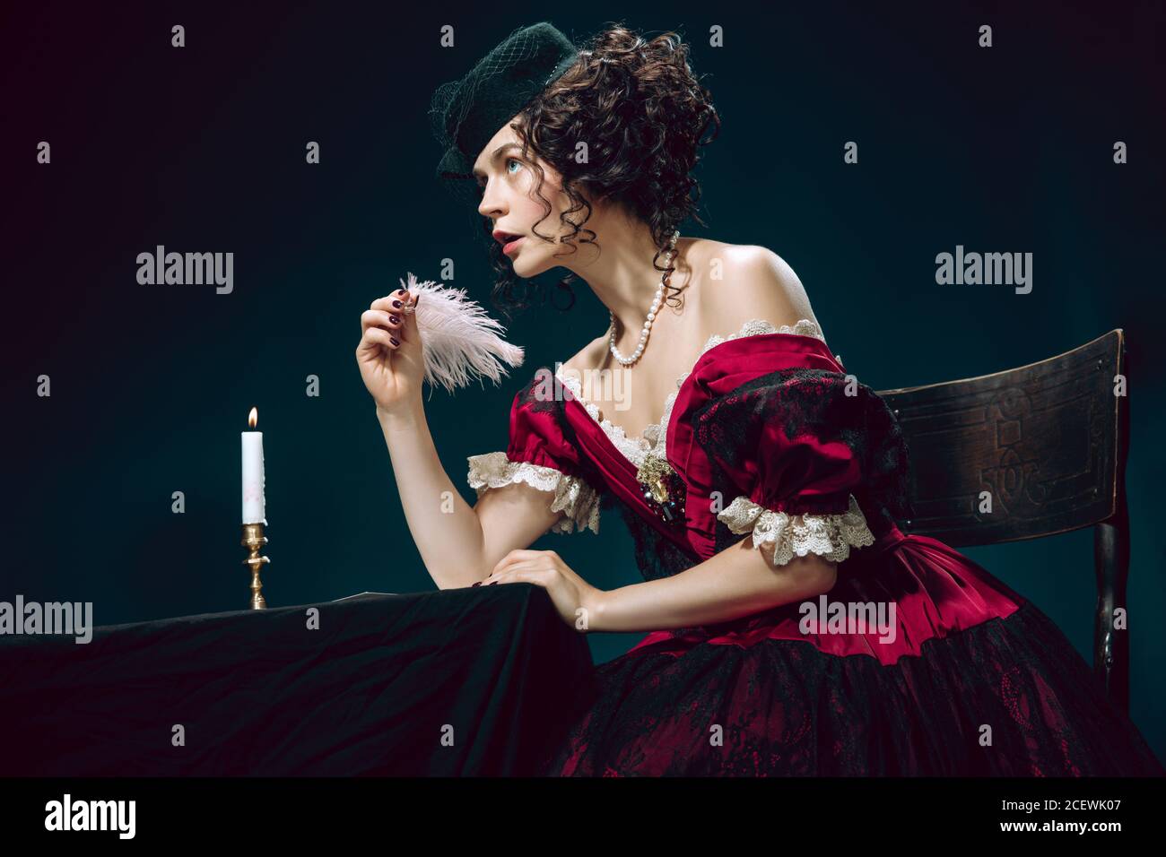 Feathers. Young woman as Anna Karenina isolated on dark blue background ...