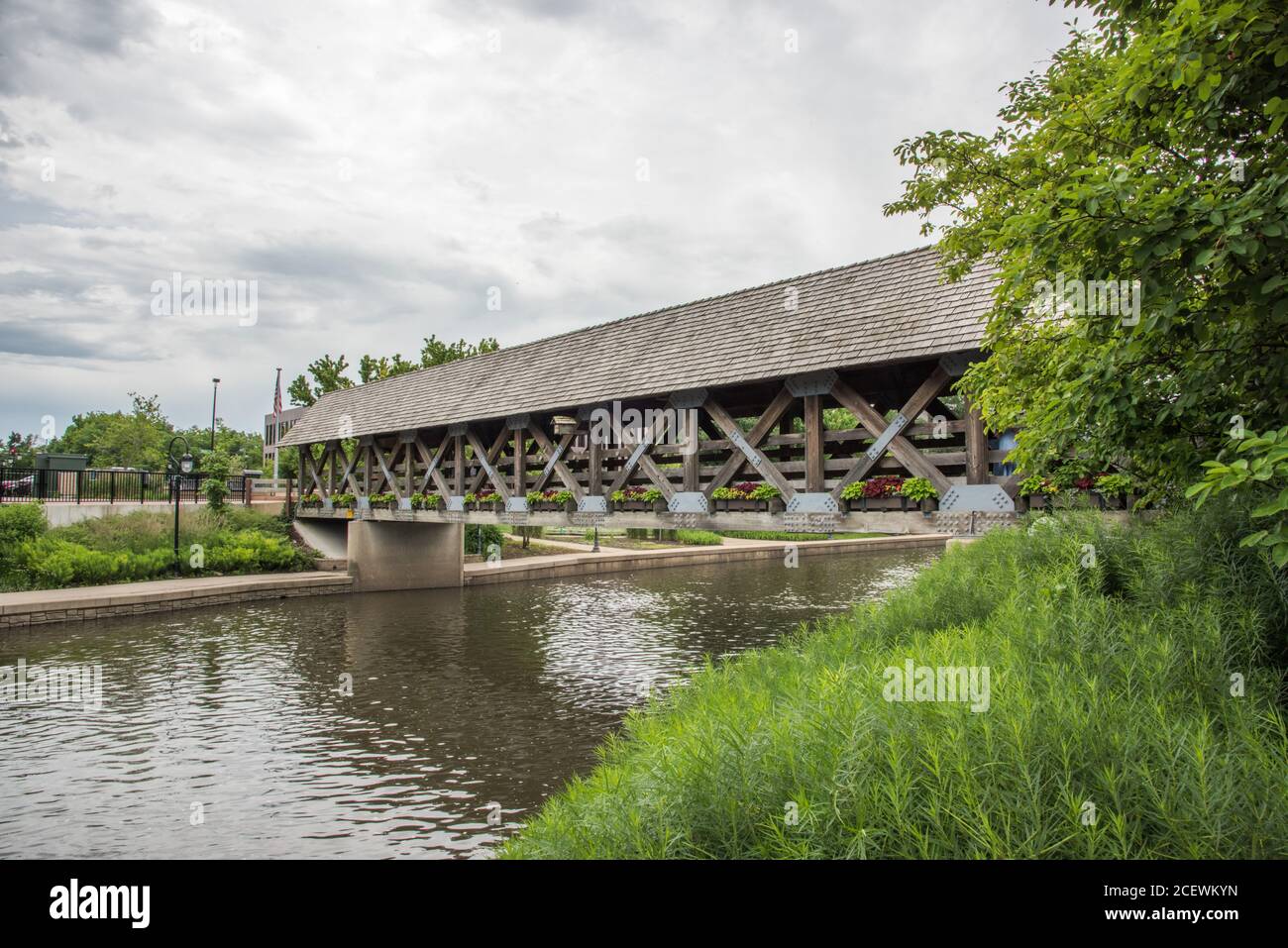 Old-fashioned covered bridge crossing at the riverwalk path over the ...
