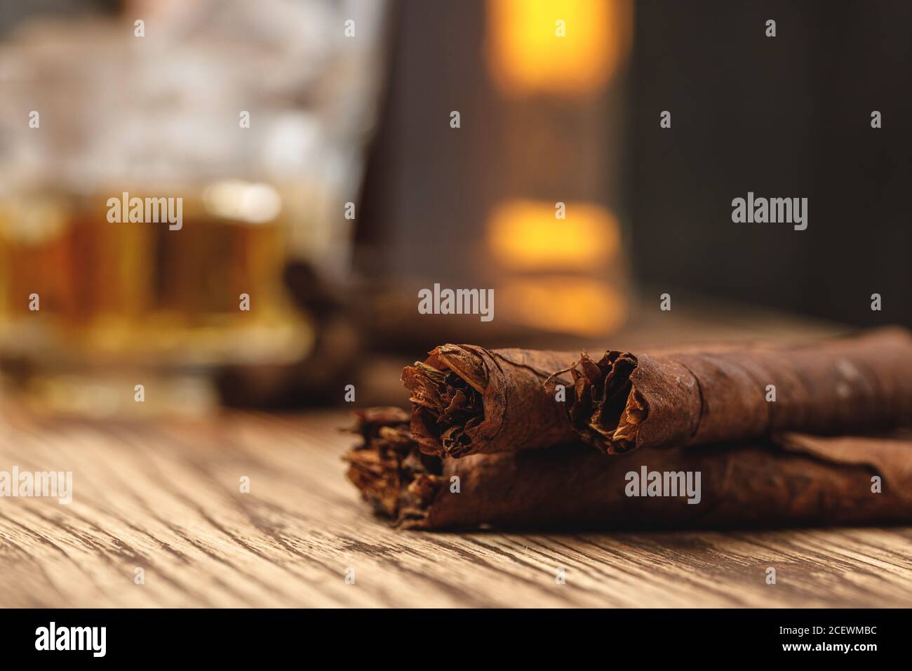 Three rolled cigarillos on wooden table close up Stock Photo - Alamy
