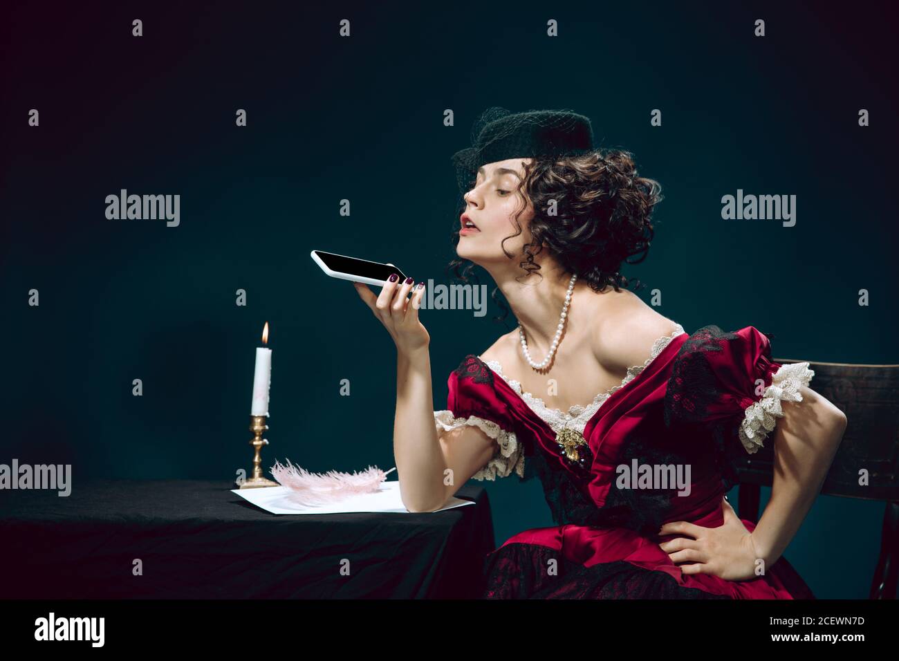 Voice recording. Young woman as Anna Karenina isolated on dark blue ...