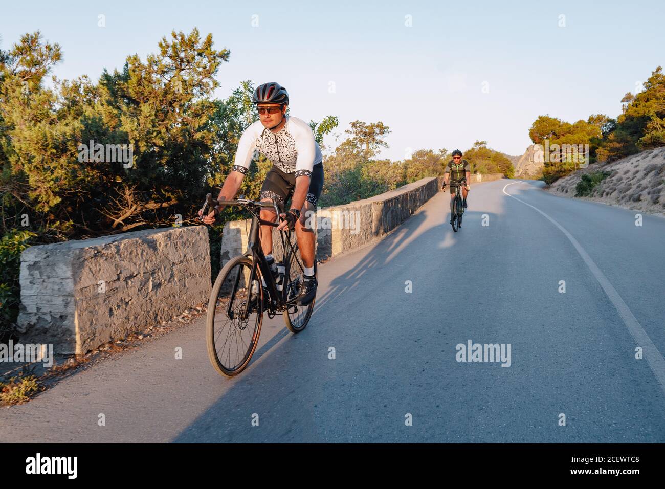Two professional male cyclists riding their racing bicycles in the ...