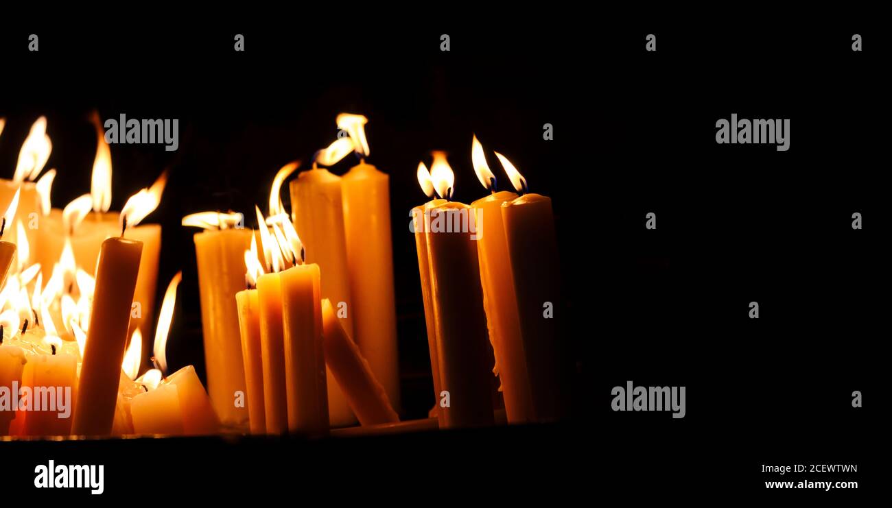 Religious candle light on black background. Yellow candlelight flame in ...