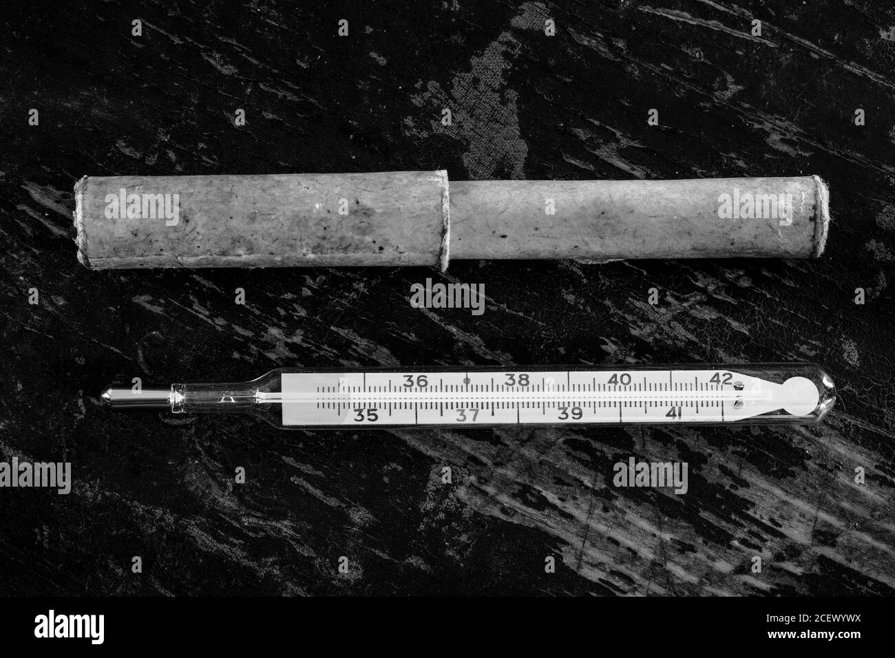 old medical mercury thermometer and paper case on black grunge wood ...