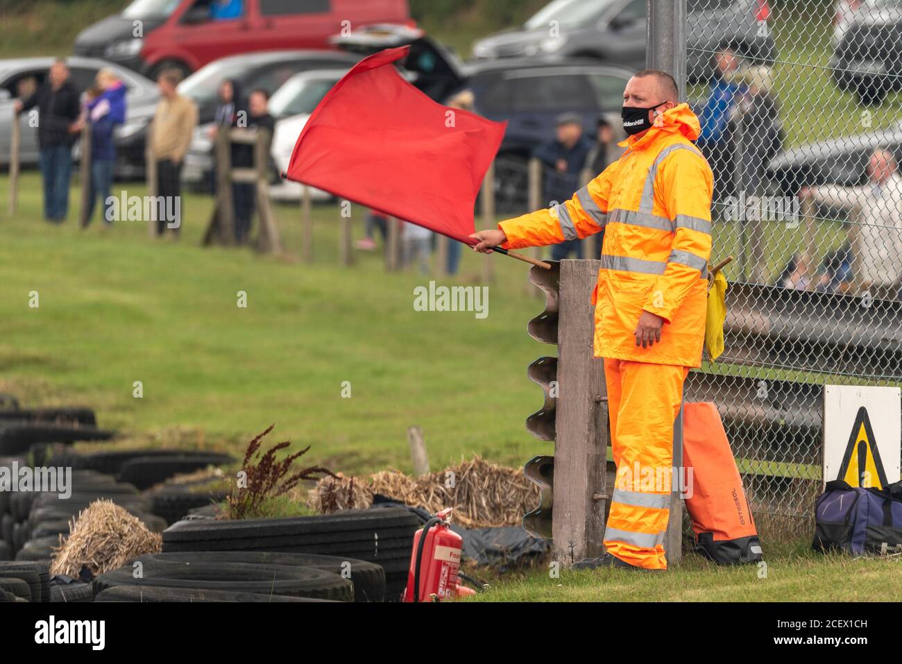 Marshal in face mask waving red flag to stop the race at the 5 Nations ...