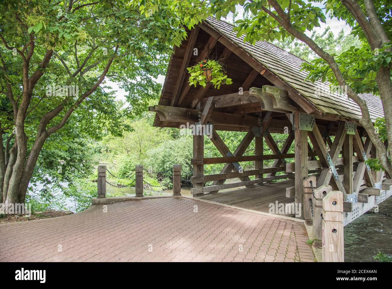 Old-fashioned covered bridge with greenery crossing over the DuPage ...
