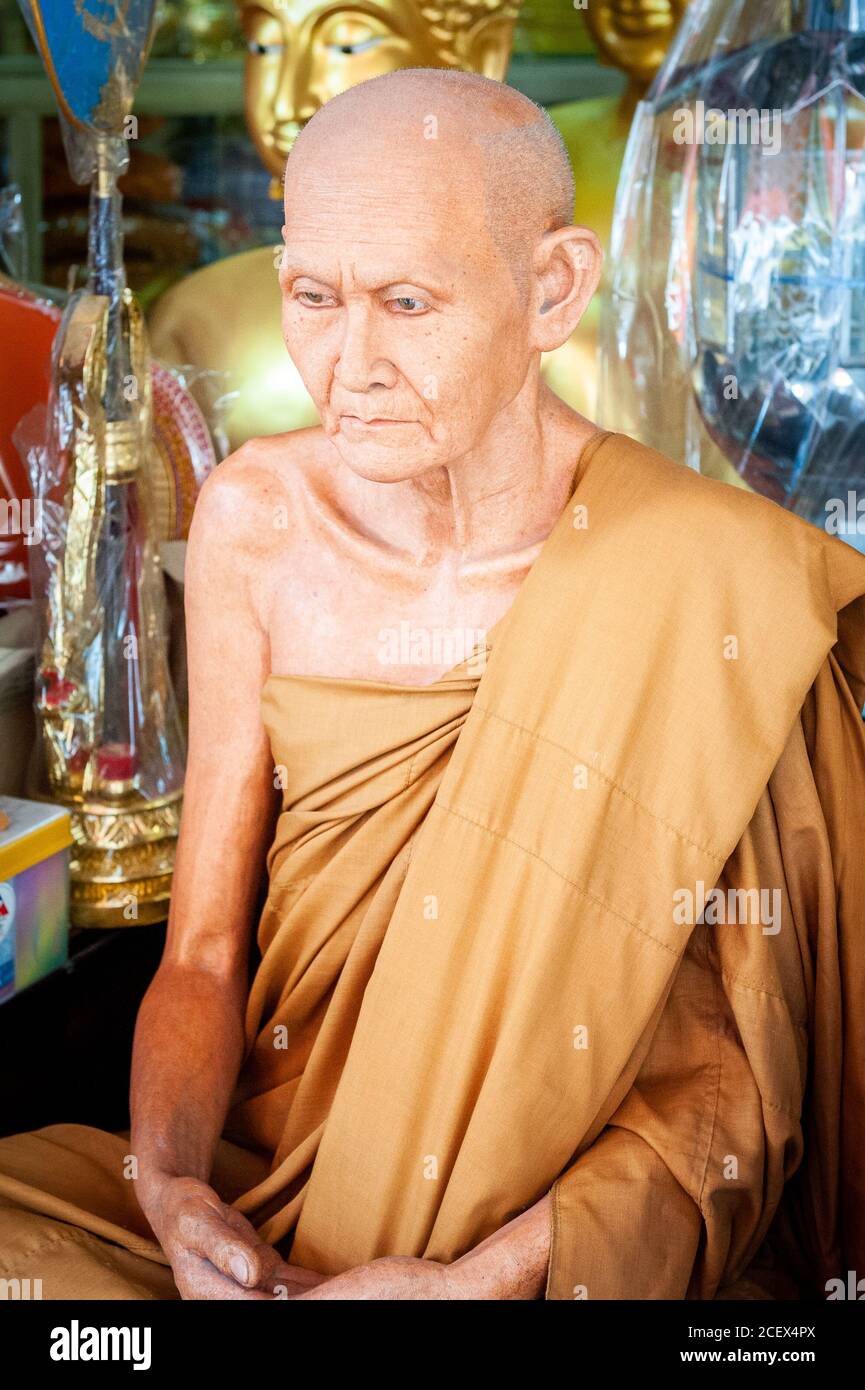 Incredibly life like mini wax models of Thai monks sit in a shop in ...