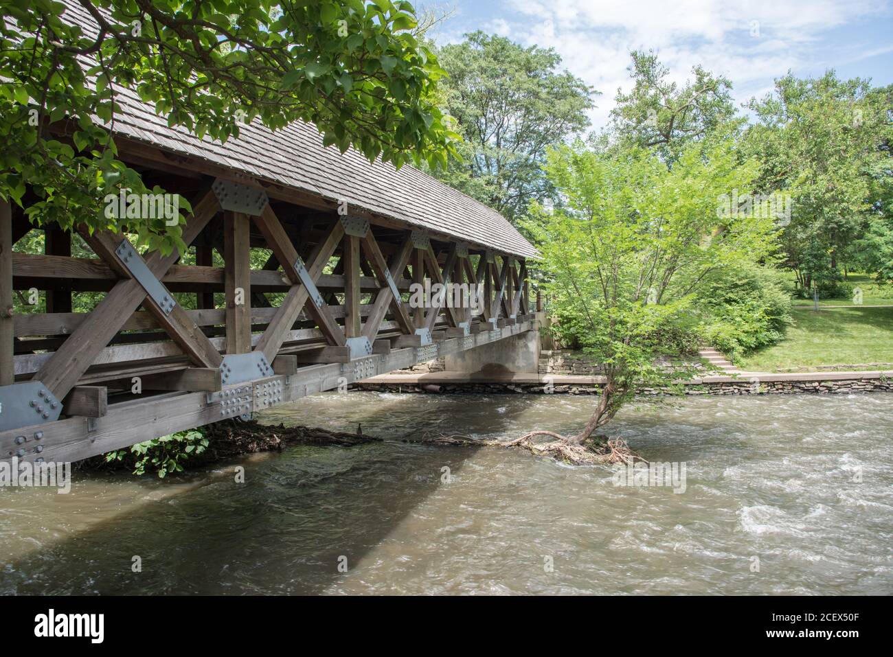 Pedestrian covered bridge crossing the DuPage River with springtime ...