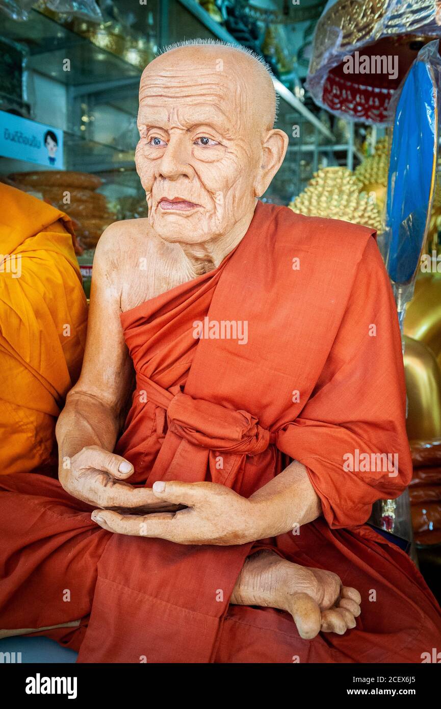 Incredibly life like mini wax models of Thai monks sit in a shop in ...