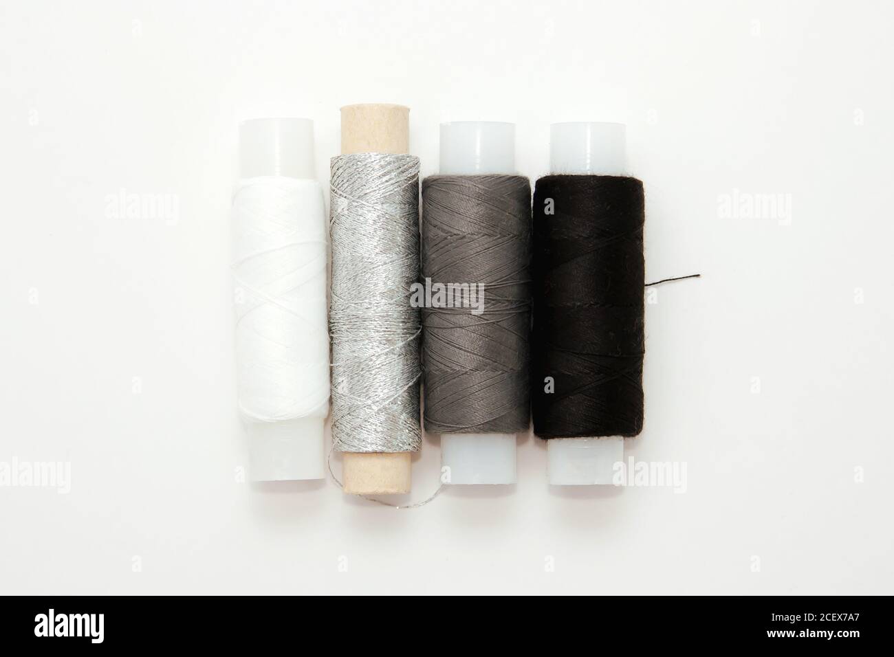 Flat lay colorful cotton thread spools, embroidery white, gray, black ...