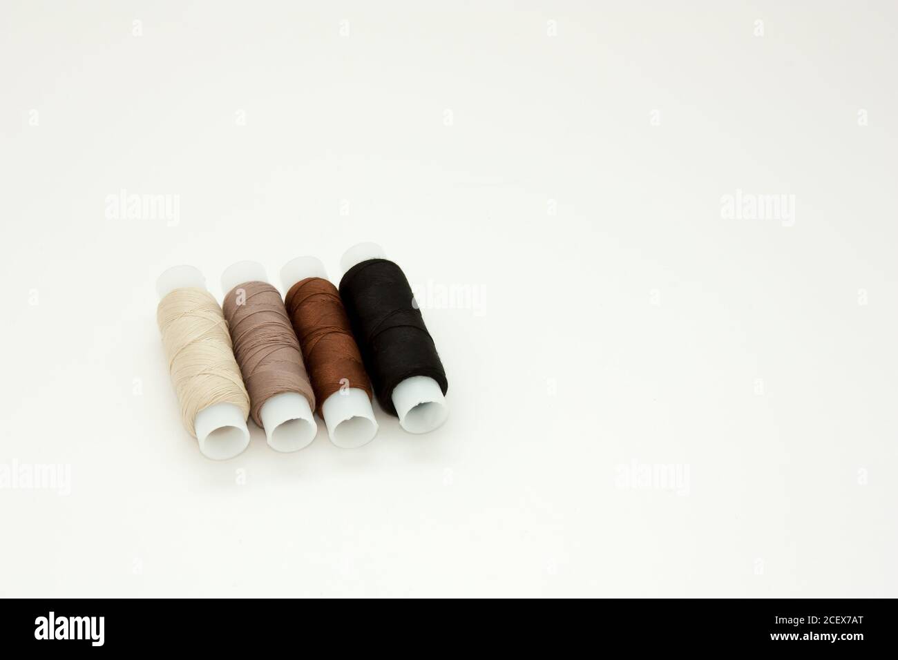 Flat lay colorful cotton thread spools, embroidery yarn, white, brown ...